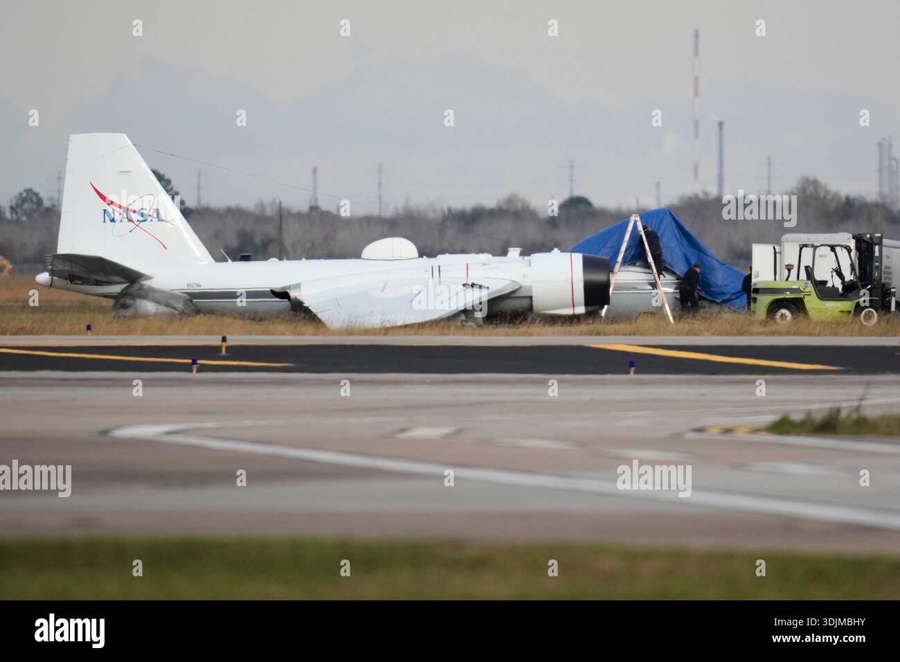 A NASA aircraft sits near a runway at Ellington Airport after making a ...