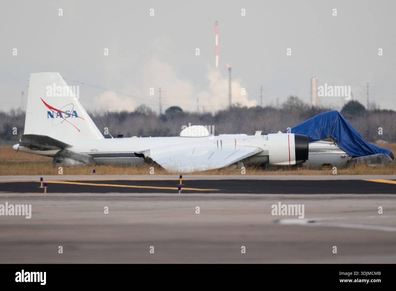 A NASA aircraft sits near a runway at Ellington Airport after making a ...