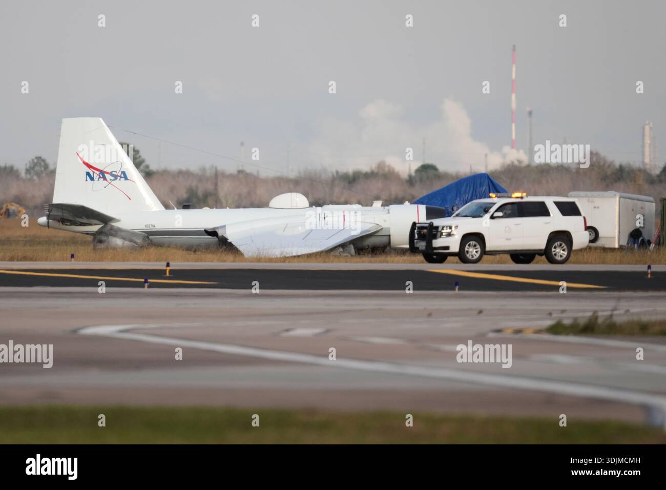 A NASA aircraft sits near a runway at Ellington Airport after making a ...