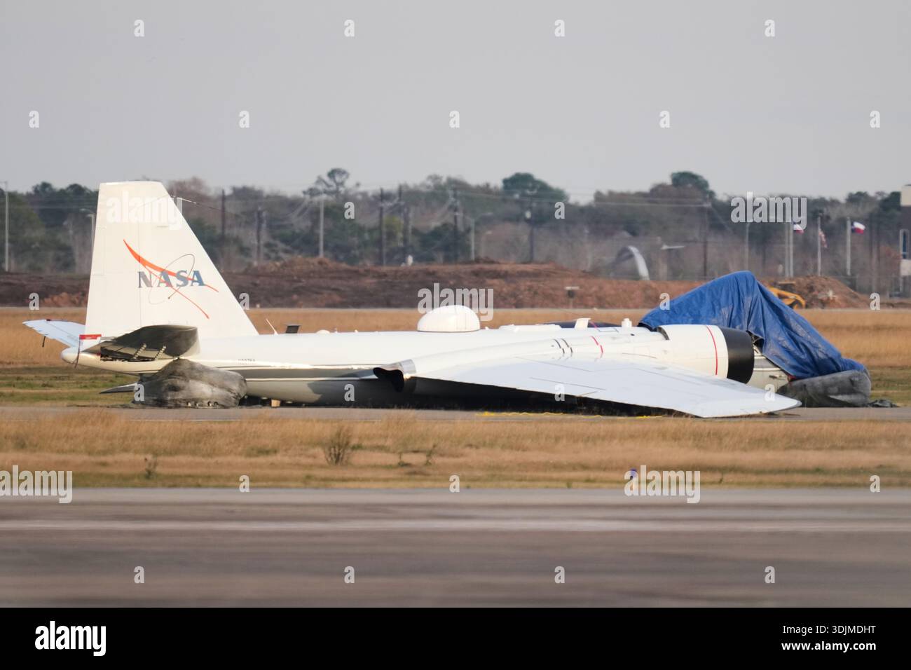 A NASA aircraft sits near a runway at Ellington Airport after making a ...
