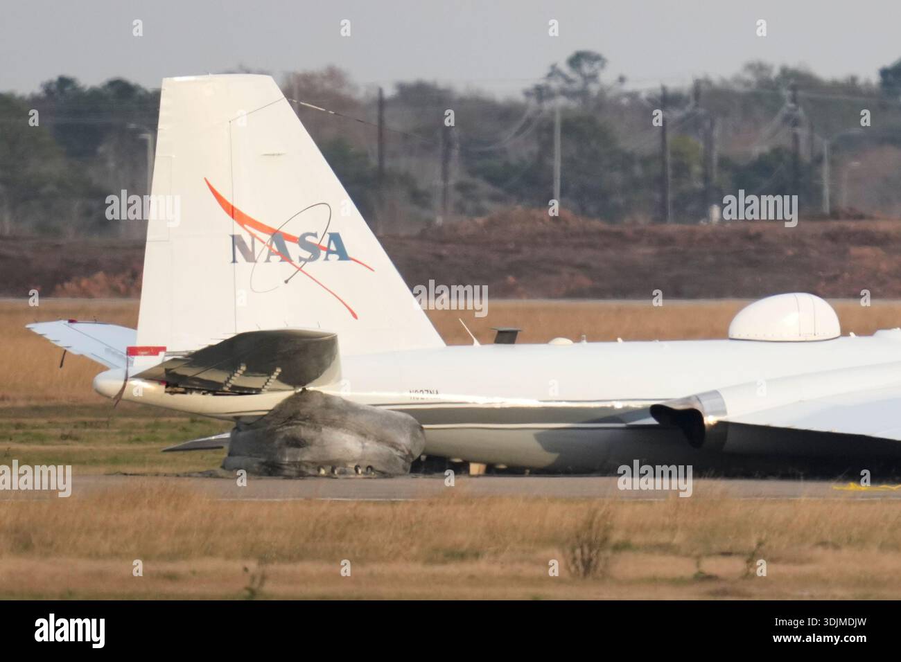 A NASA aircraft sits near a runway at Ellington Airport after making a ...
