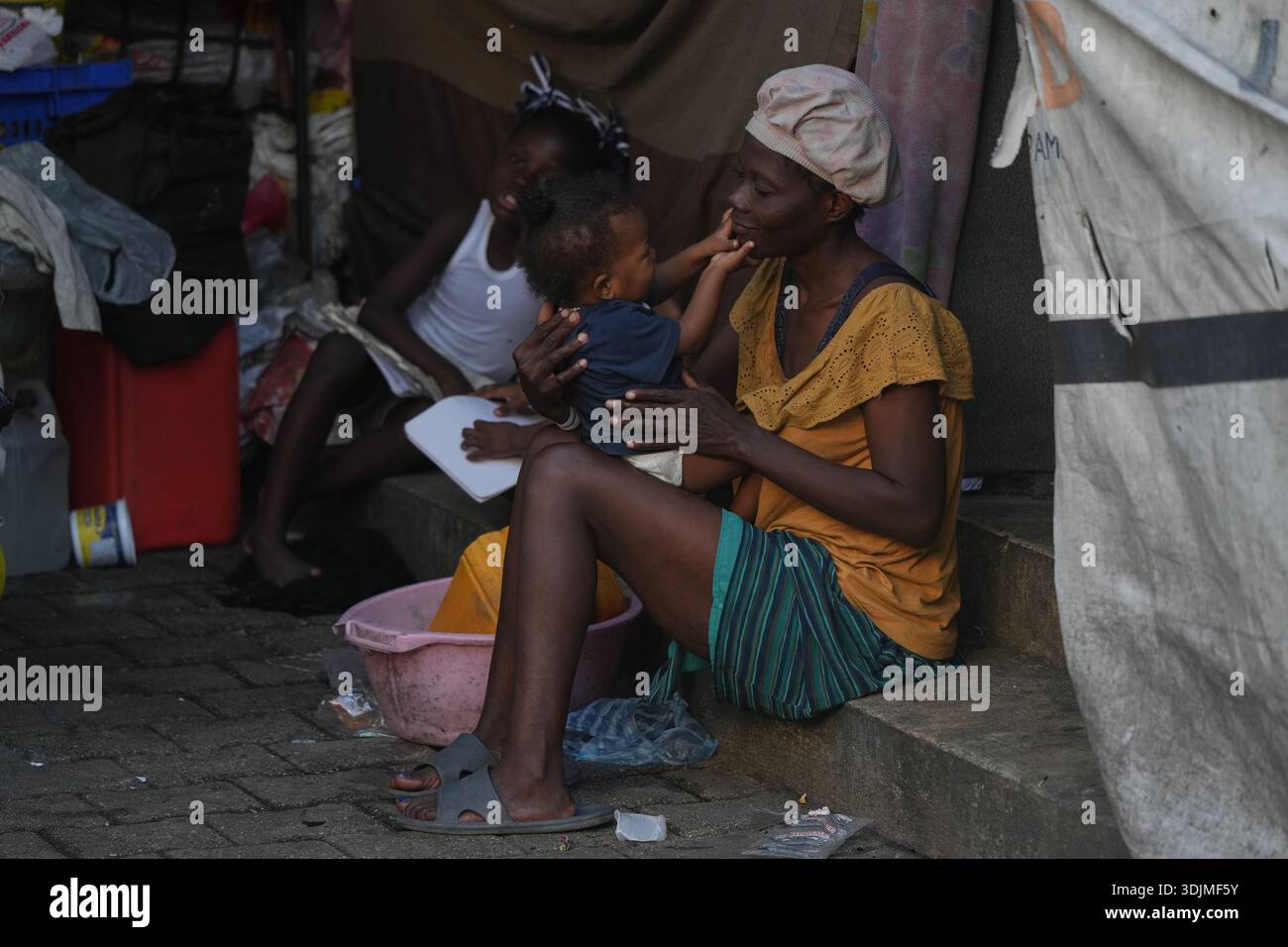 A woman holds her child at a shelter for families displaced by gang ...