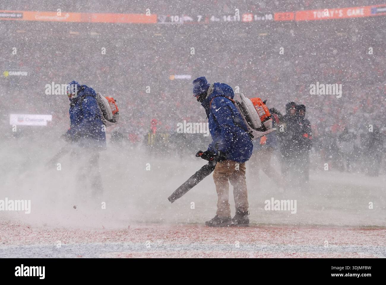 Field workers use blowers to clear snow from the yard lines in the AFC ...