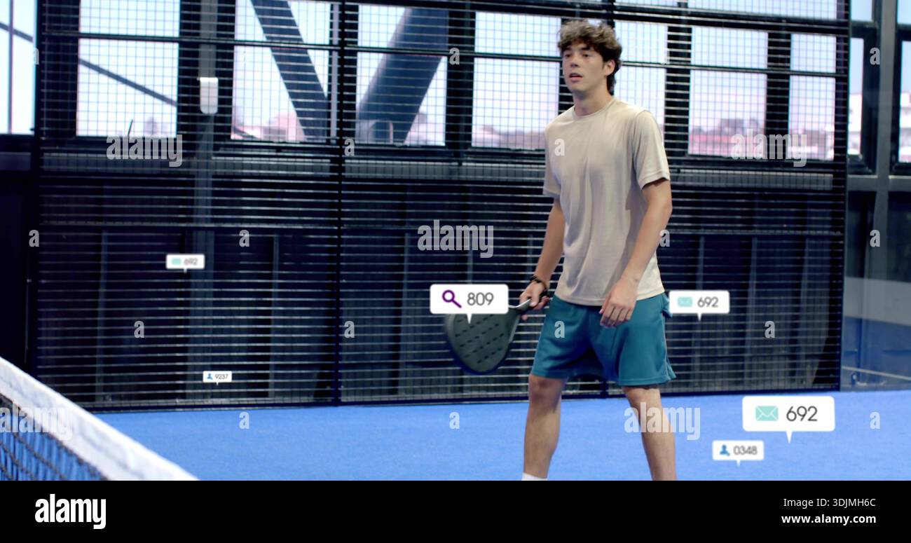 Standing man wearing beige-tee teal-shorts holding padel racket at blue ...