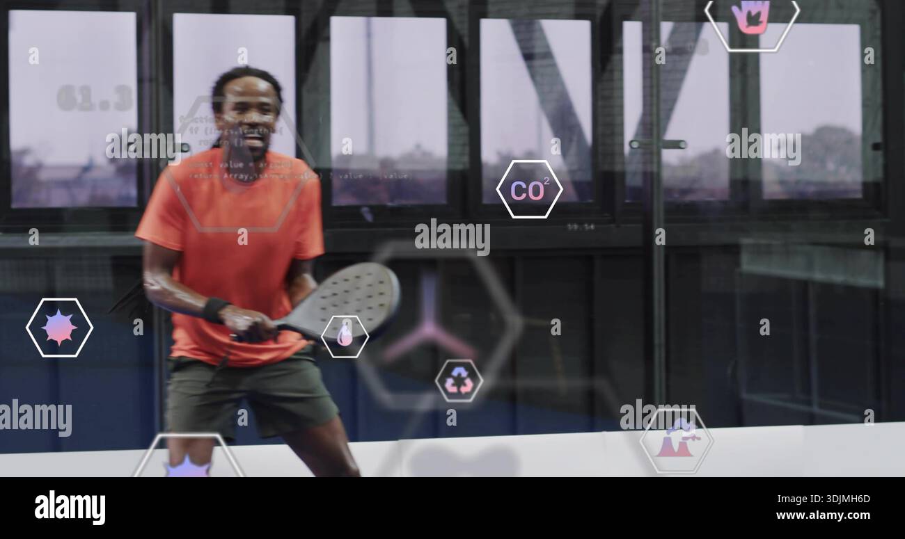 Swinging man wearing orange shirt holding padel racket and wristband at ...