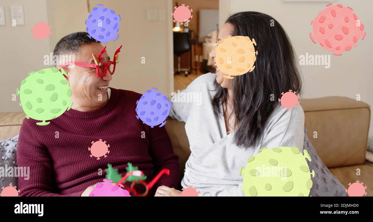 Smiling couple leaning on sofa man wearing burgundy knit red reindeer ...