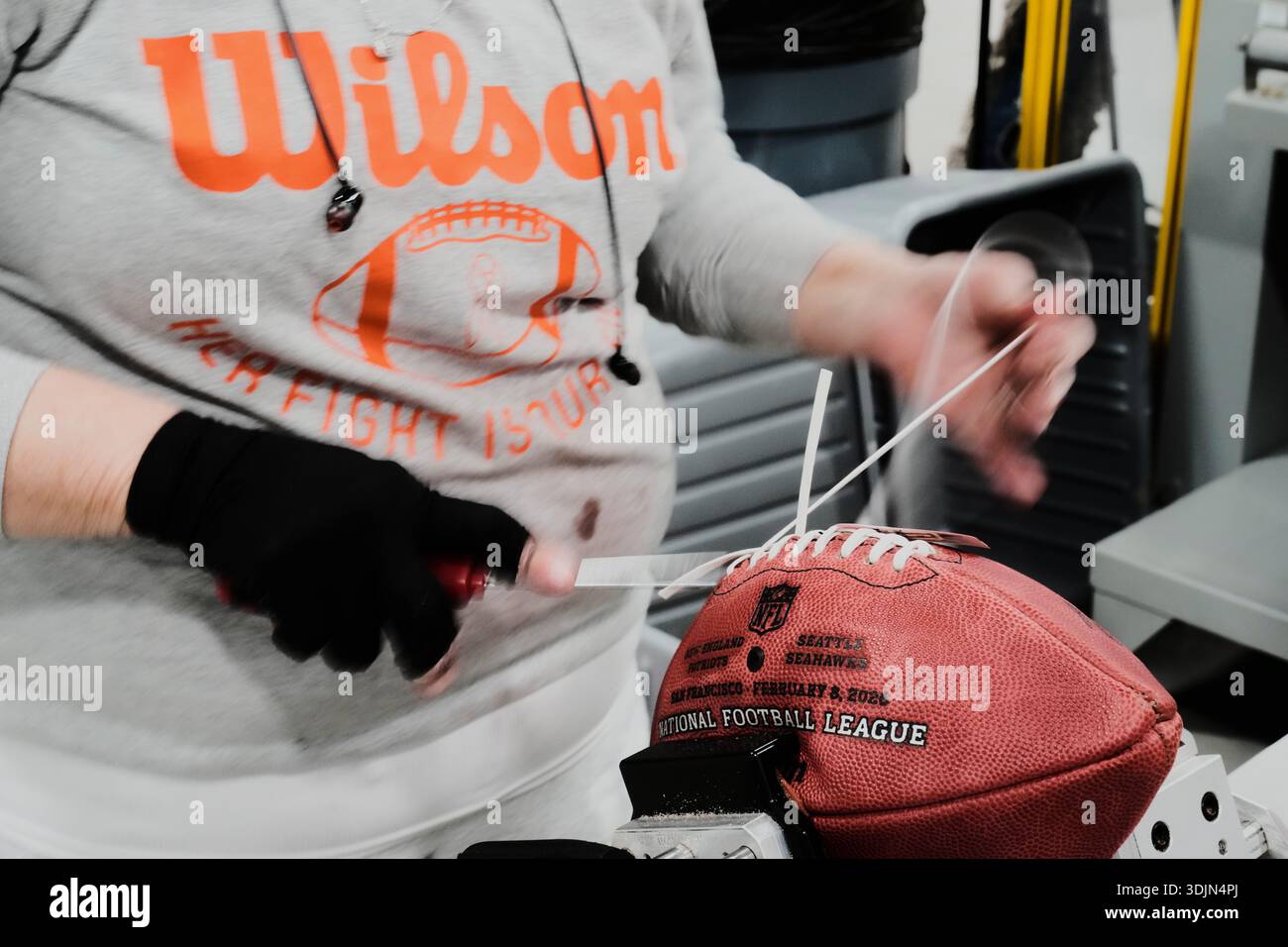 Heather Nicely, of Lima, Ohio, laces a commemorative football with the ...