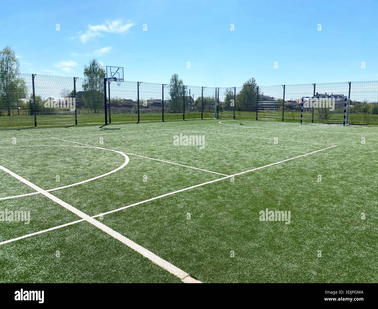 Outdoor basketball court with artificial turf is surrounded by green ...