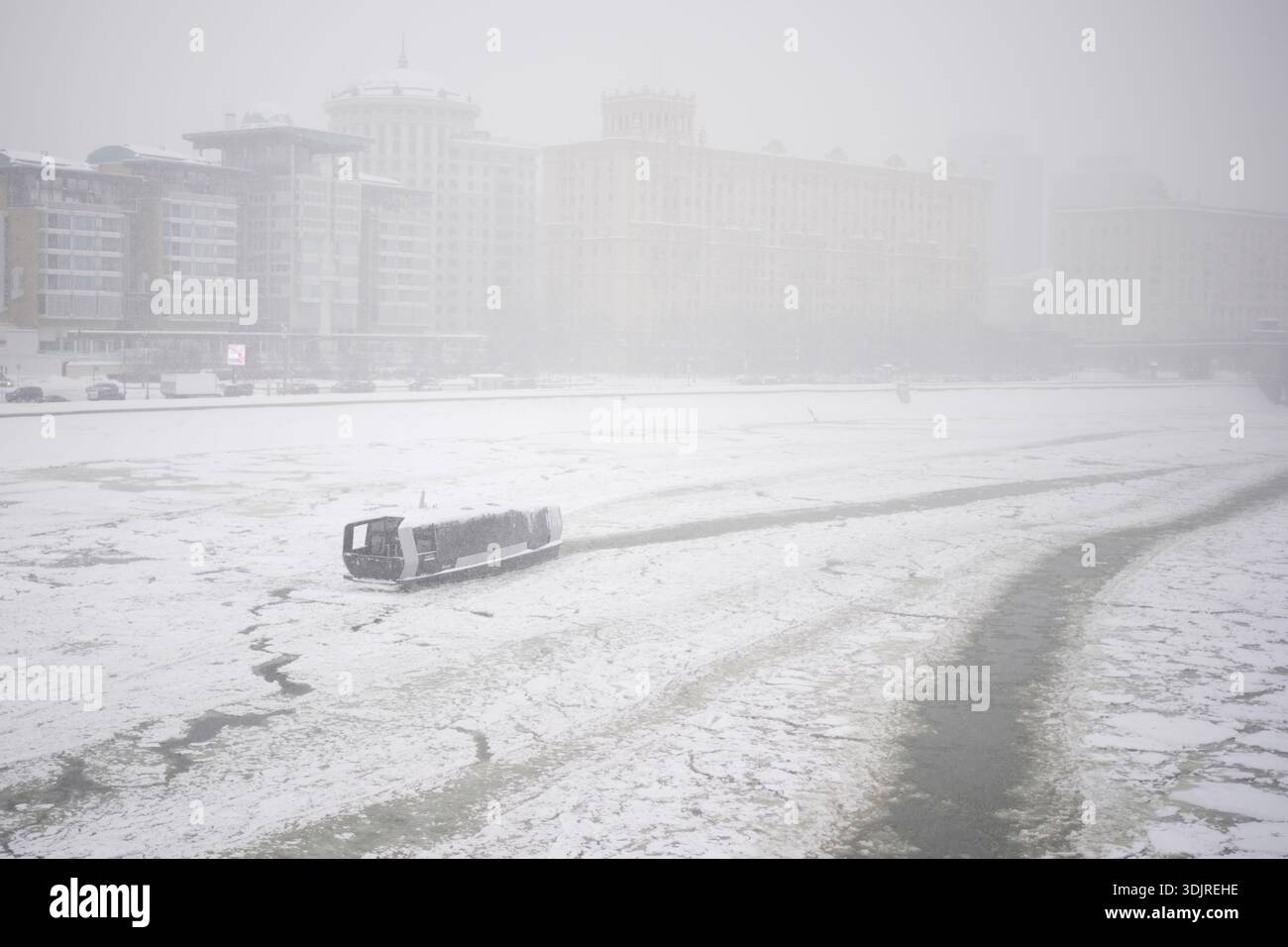 A boat navigates through the ice-covered Moskva River during heavy ...