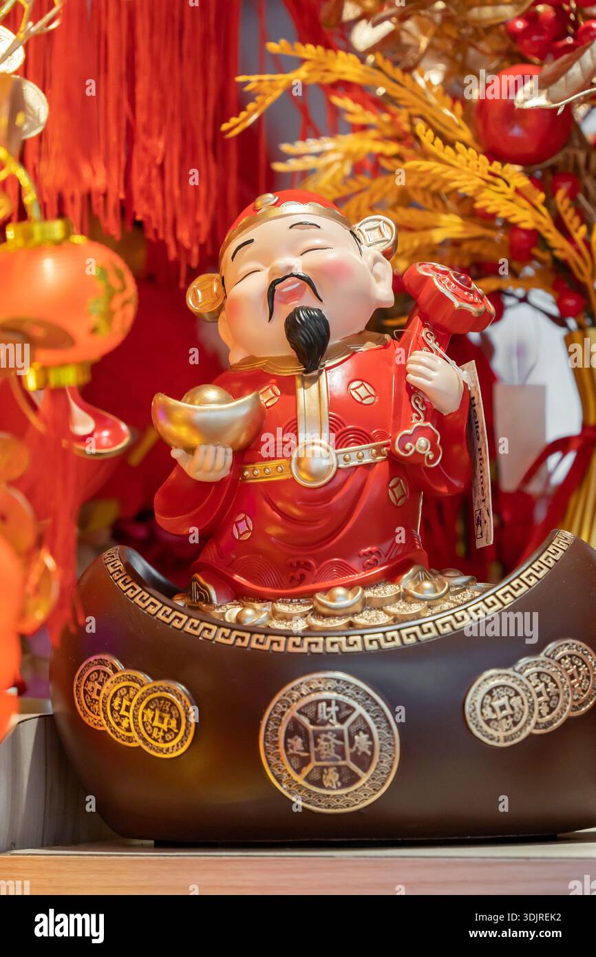 Vibrant prosperity god statue in a gold bowl filled with coins ...