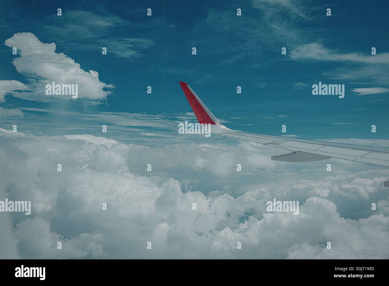 A photograph taken from an airplane window showcasing a bright blue sky ...