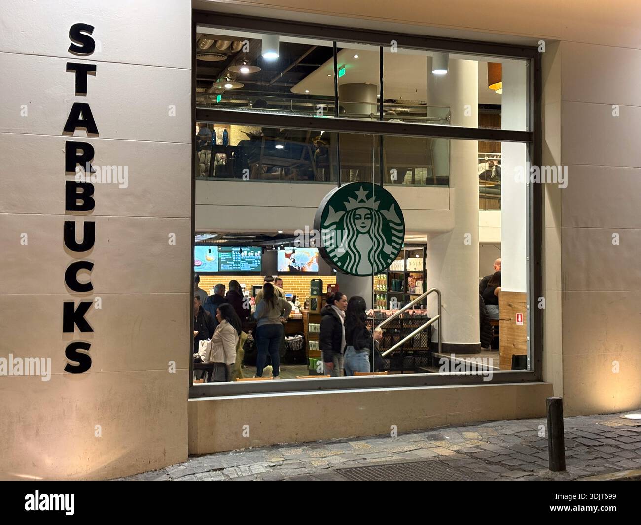 Starbucks coffee shop exterior sign and window showing patrons inside ...