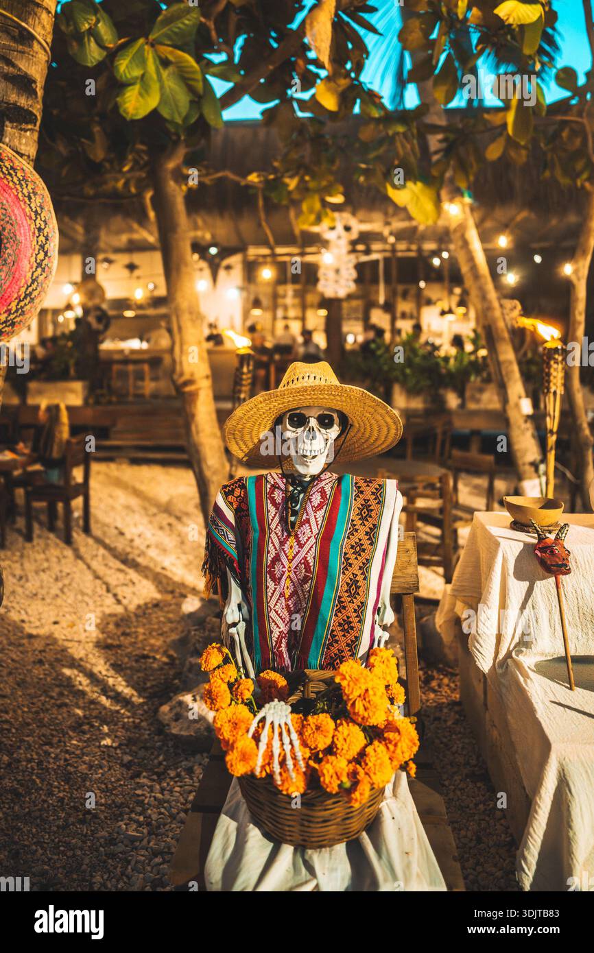 Decorative skeleton figure holding marigolds in an outdoor restaurant ...