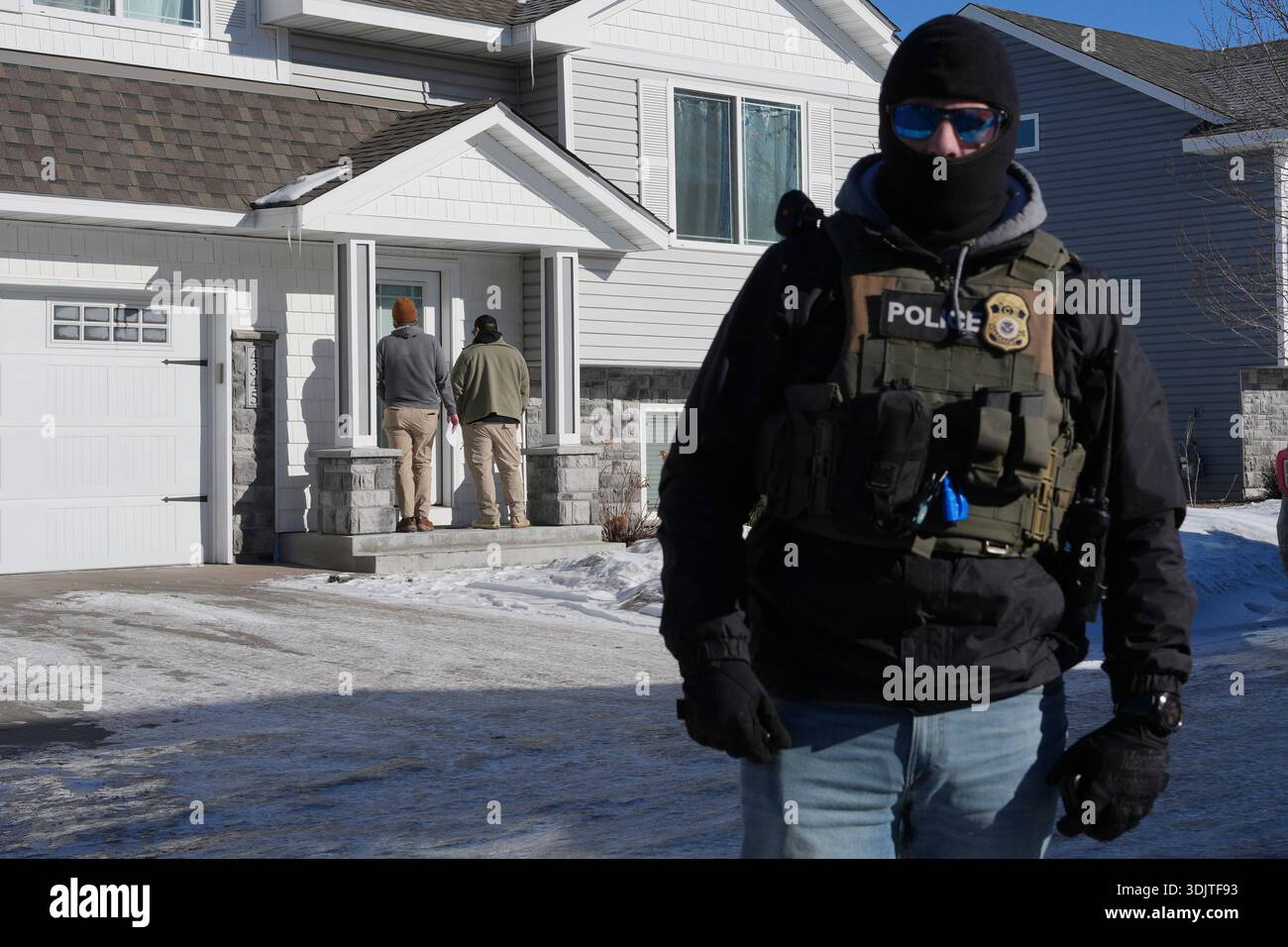 Federal agents knock on a door of a residence on Wednesday, Jan. 28 ...