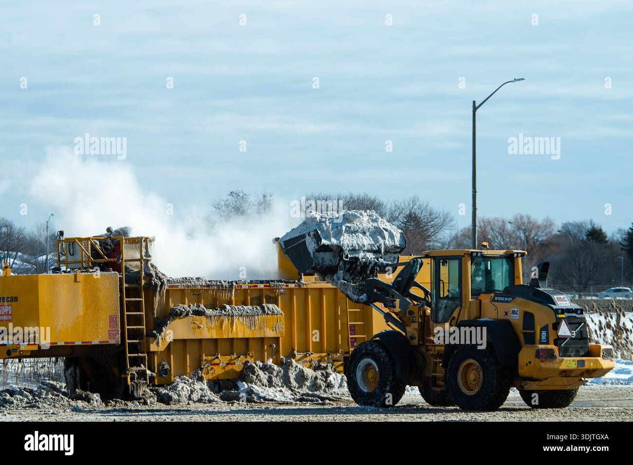 A machine lifts snow into a snow melter at one of Toronto‚Äôs snow dump ...