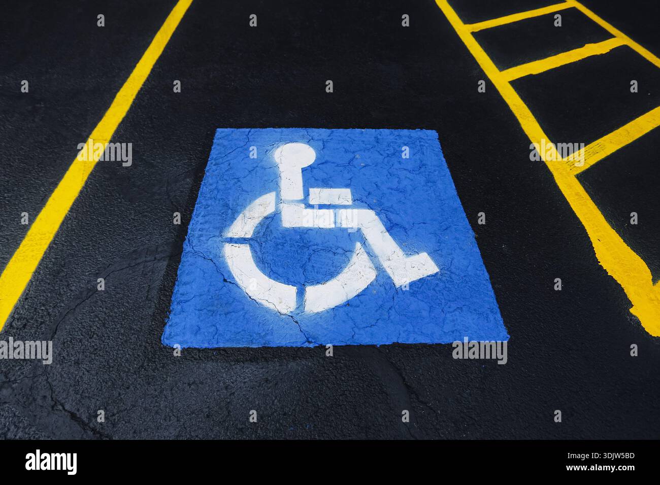 Accessible parking space symbol painted on asphalt surface. Blue ...