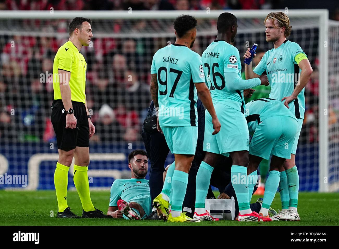 Sporting's Goncalo Inacio lies on the pitch next to referee Felix ...