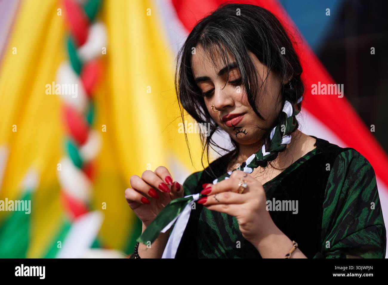 A Kurdish woman braids her hair during a demonstration in solidarity ...
