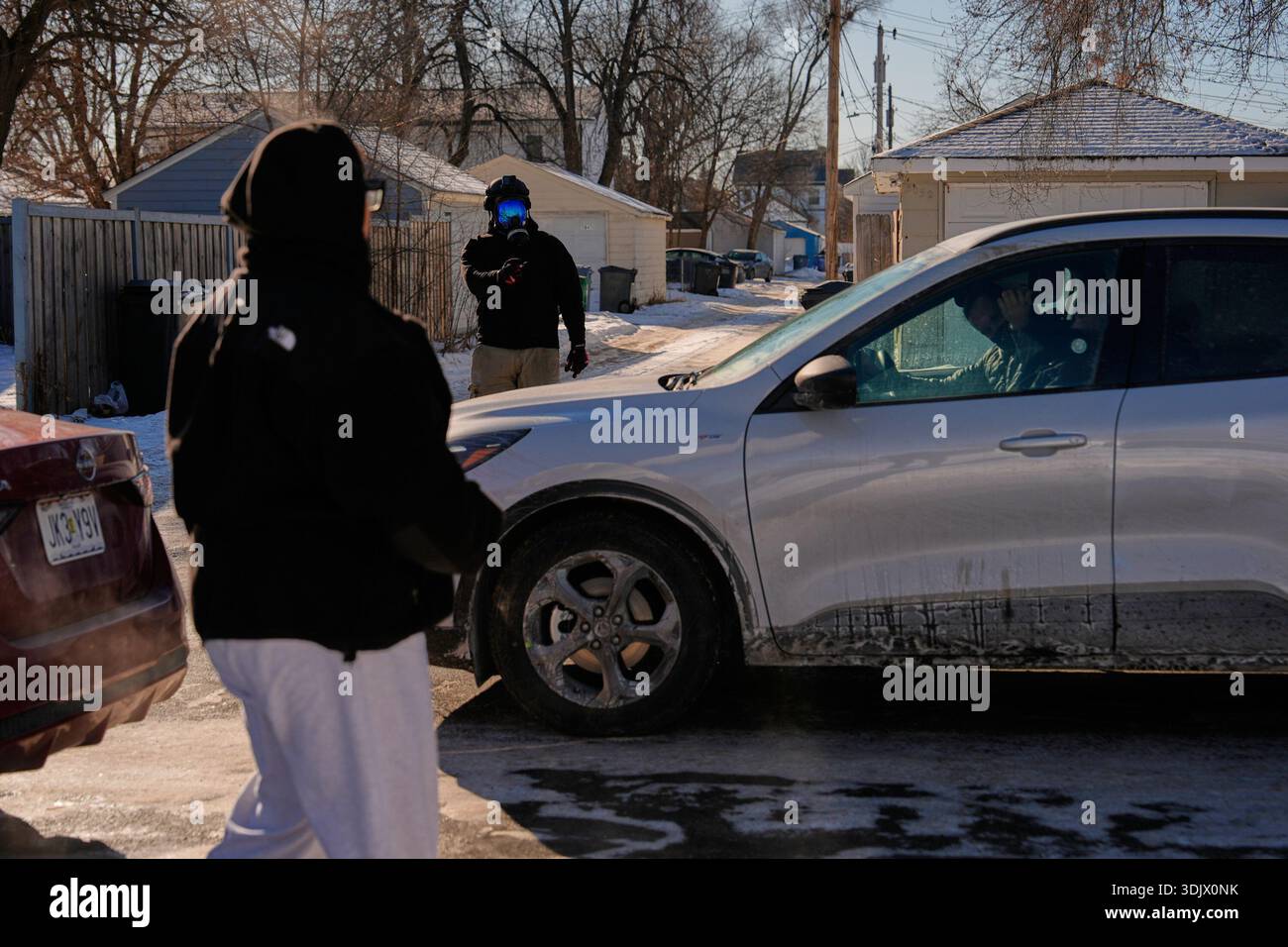 Observers surround a federal immigration officer's vehicle Wednesday ...