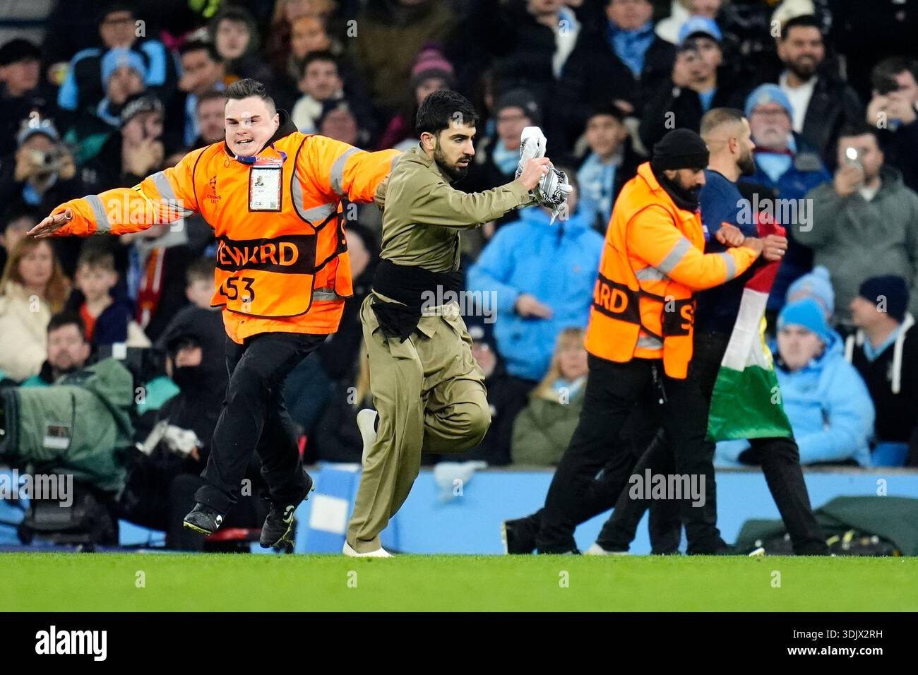 Pitch invaders are escorted off the pitch by the match stewards during ...
