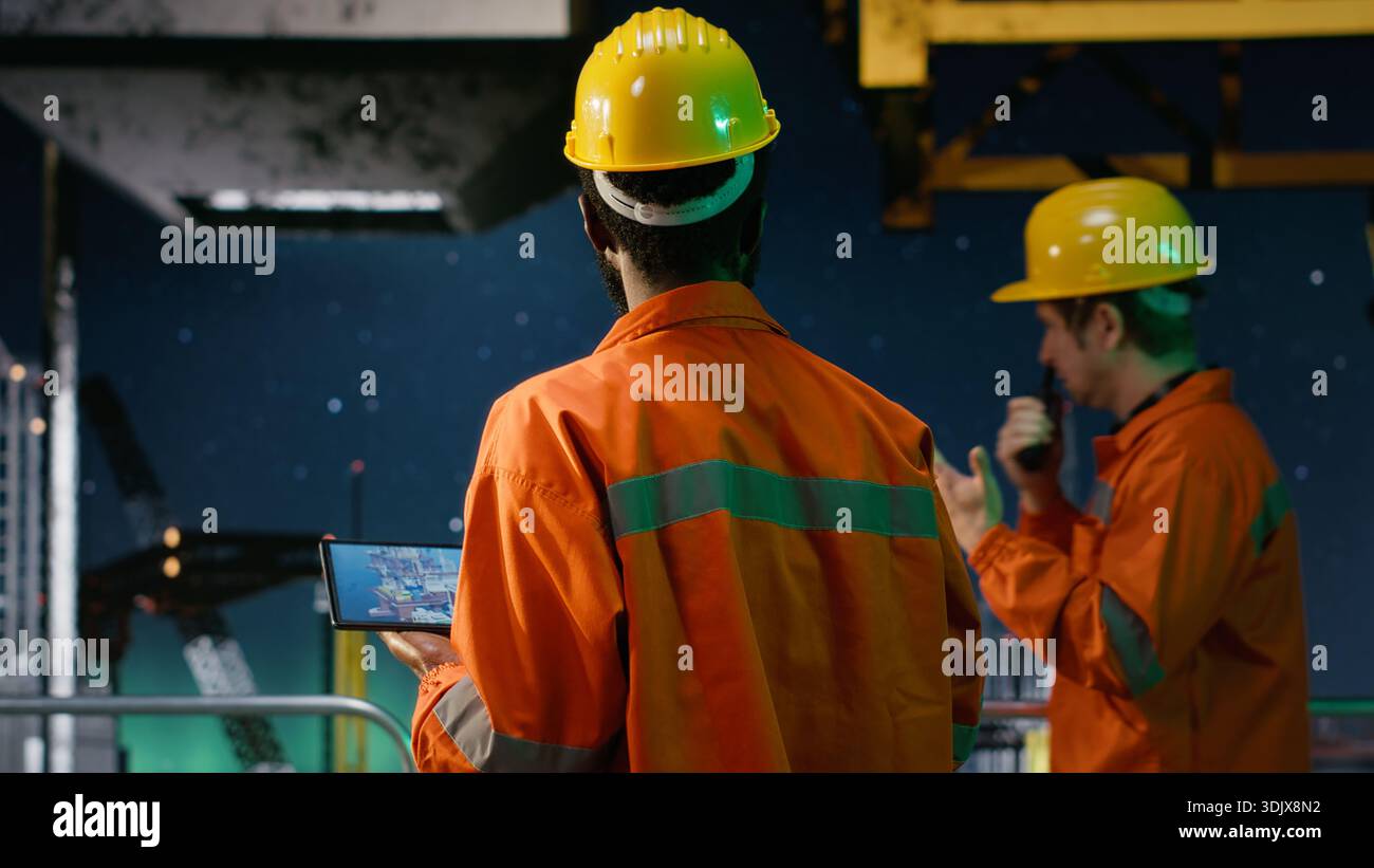 Environmental officer uses tablet on offshore rig under the northern ...