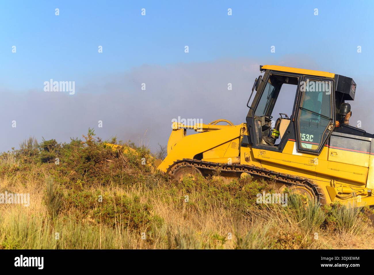 Fire prevention strategy using a bulldozer to create a fire line Stock ...