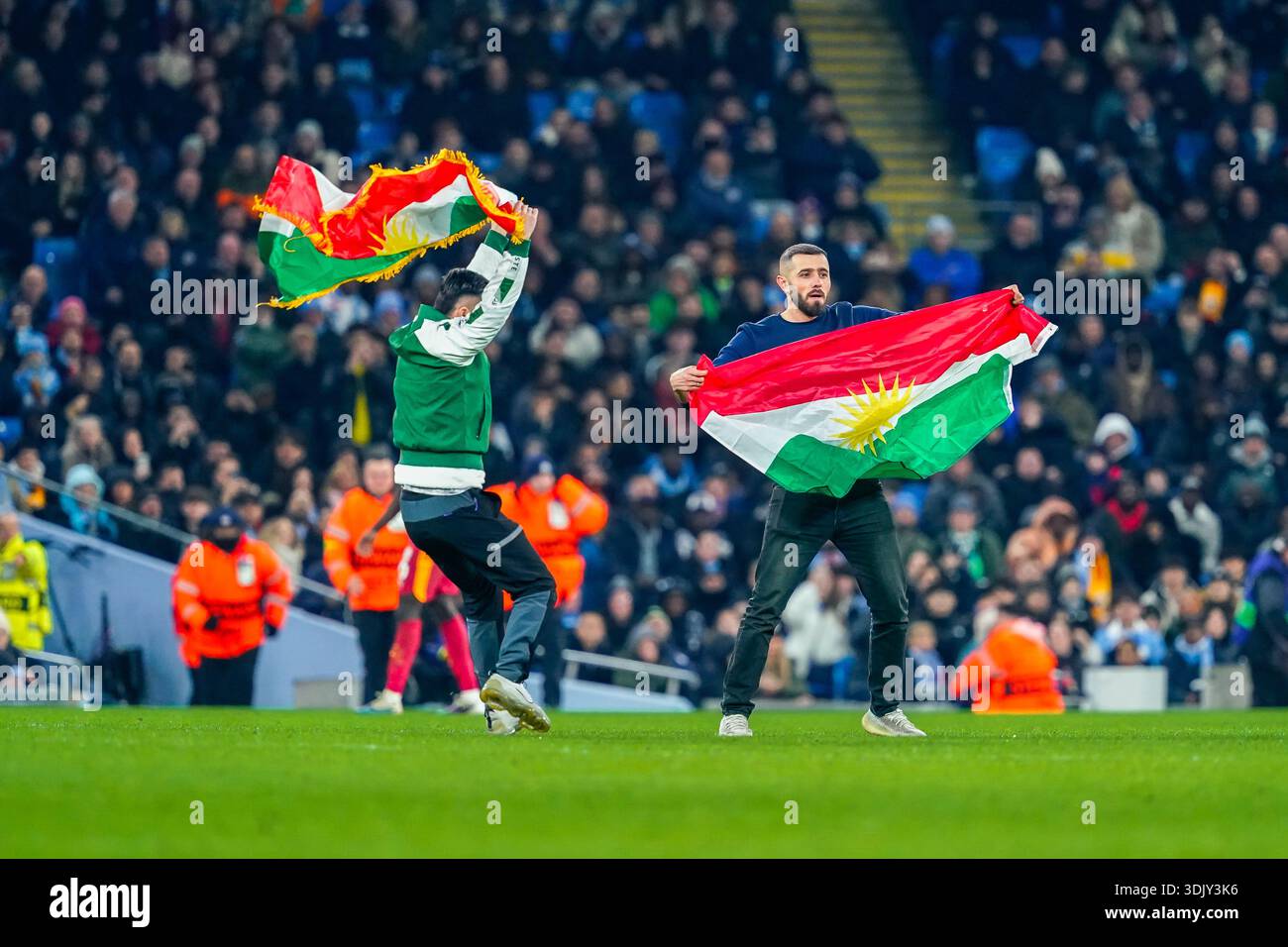 MANCHESTER, ENGLAND - January 28: Two people run onto the pitch with ...