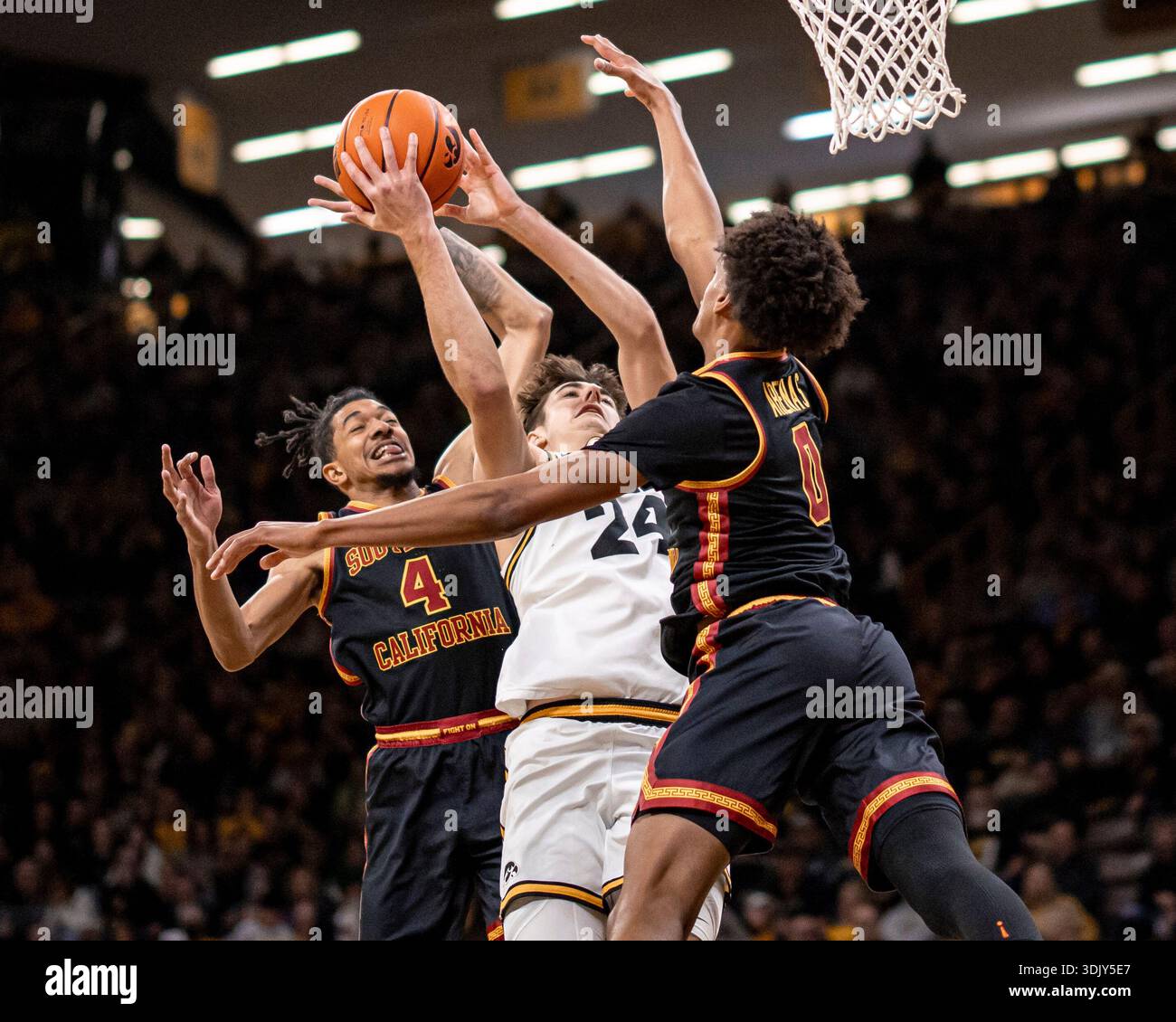USC's Amarion Dickerson (4) and Alijah Arenas (0) defend Iowa guard ...