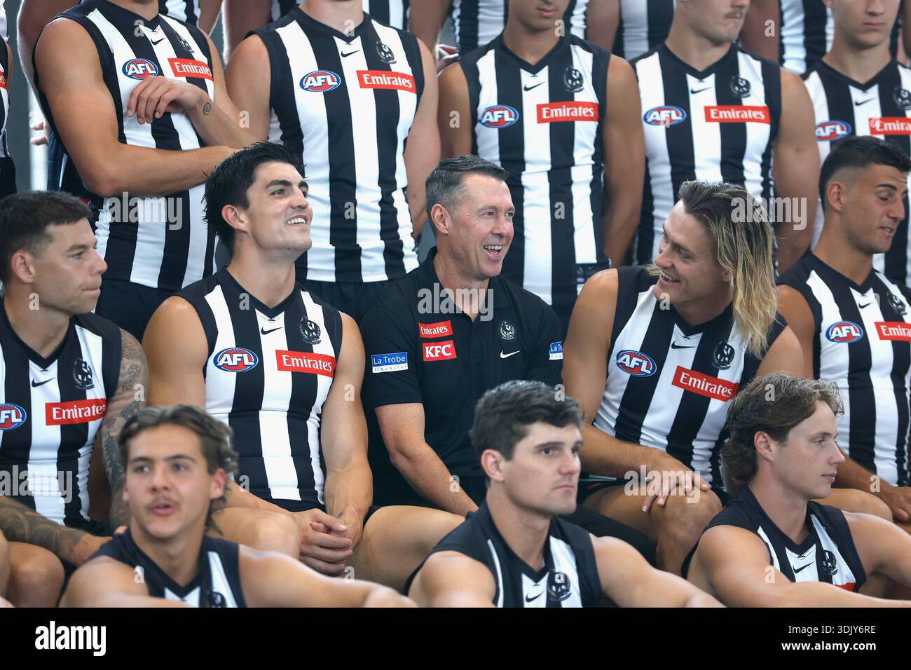 Coach Craig McRae and Collingwood AFL players pose for a team photo at ...