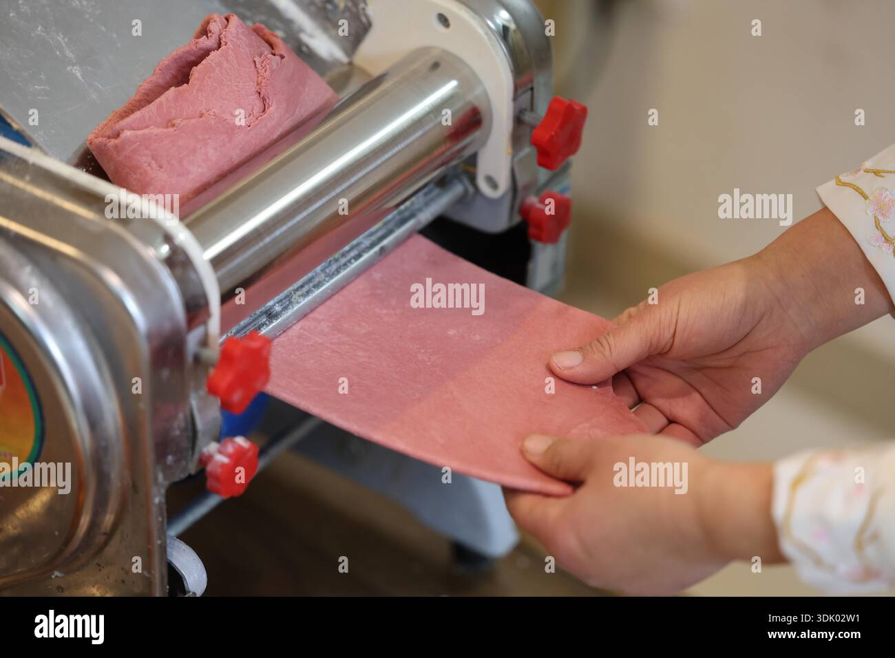 A worker displays freshly steamed traditional flower buns at a heritage ...