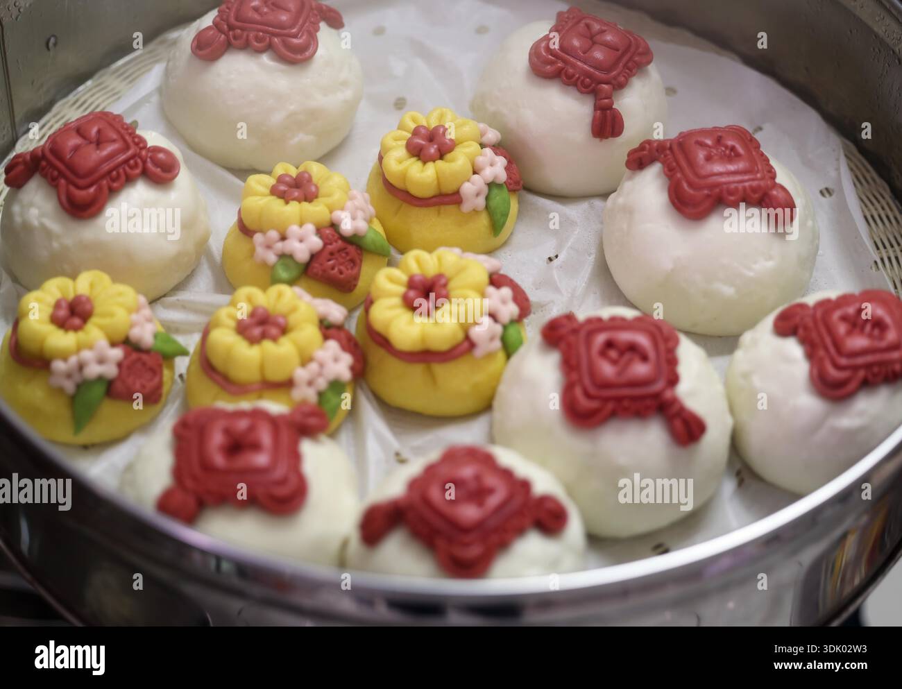 A worker displays freshly steamed traditional flower buns at a heritage ...