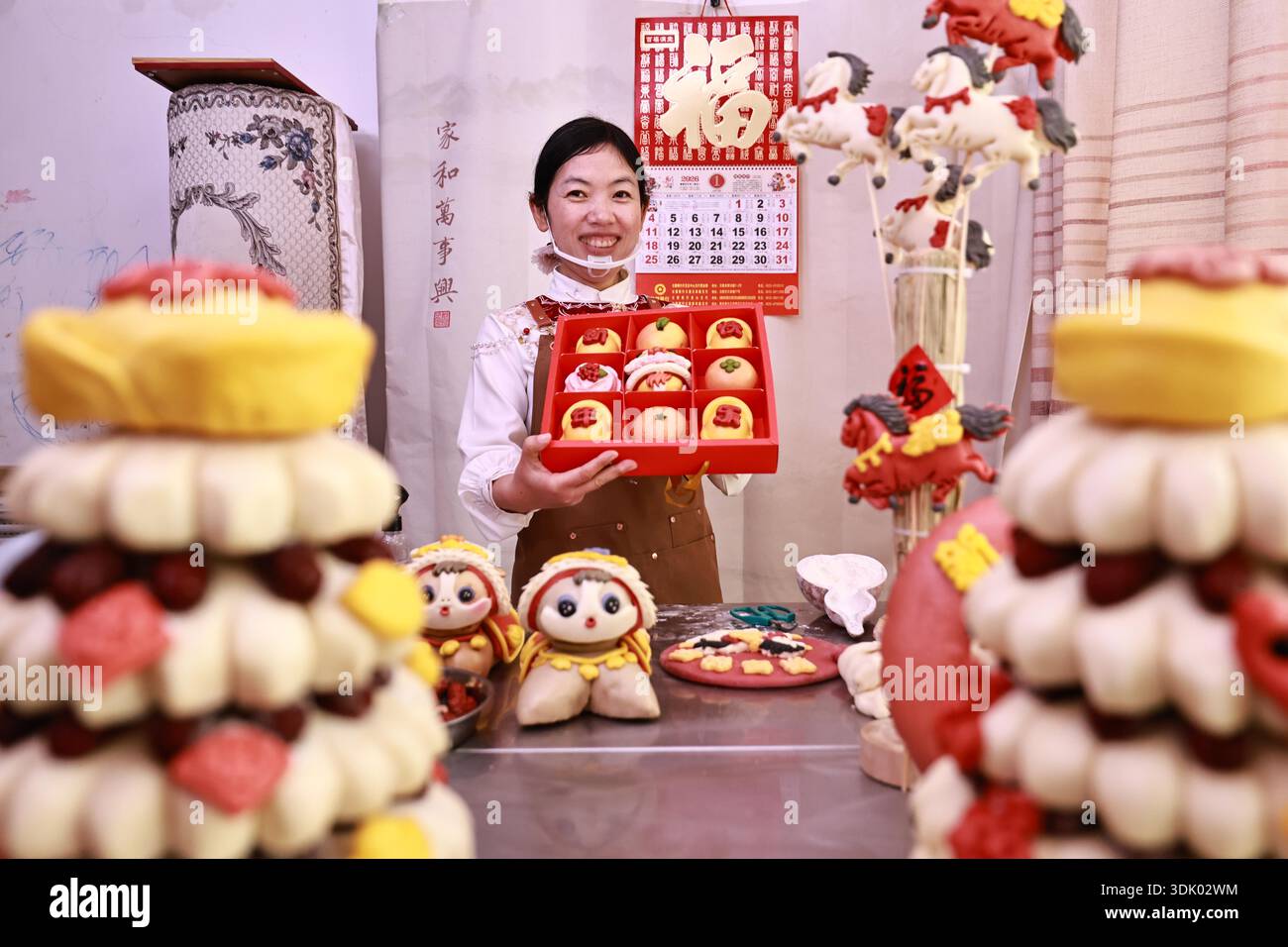A worker displays freshly steamed traditional flower buns at a heritage ...