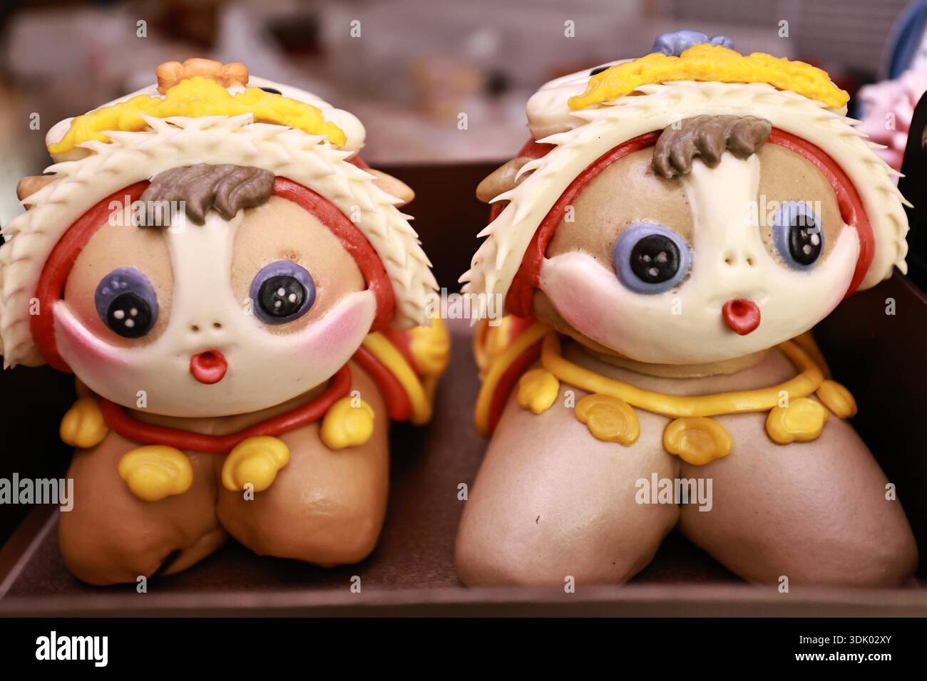 A worker displays freshly steamed traditional flower buns at a heritage ...
