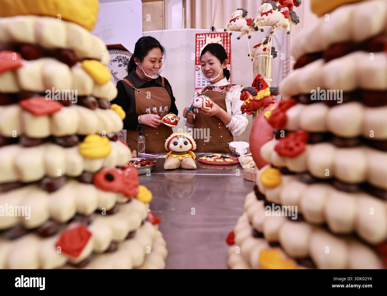 A worker displays freshly steamed traditional flower buns at a heritage ...