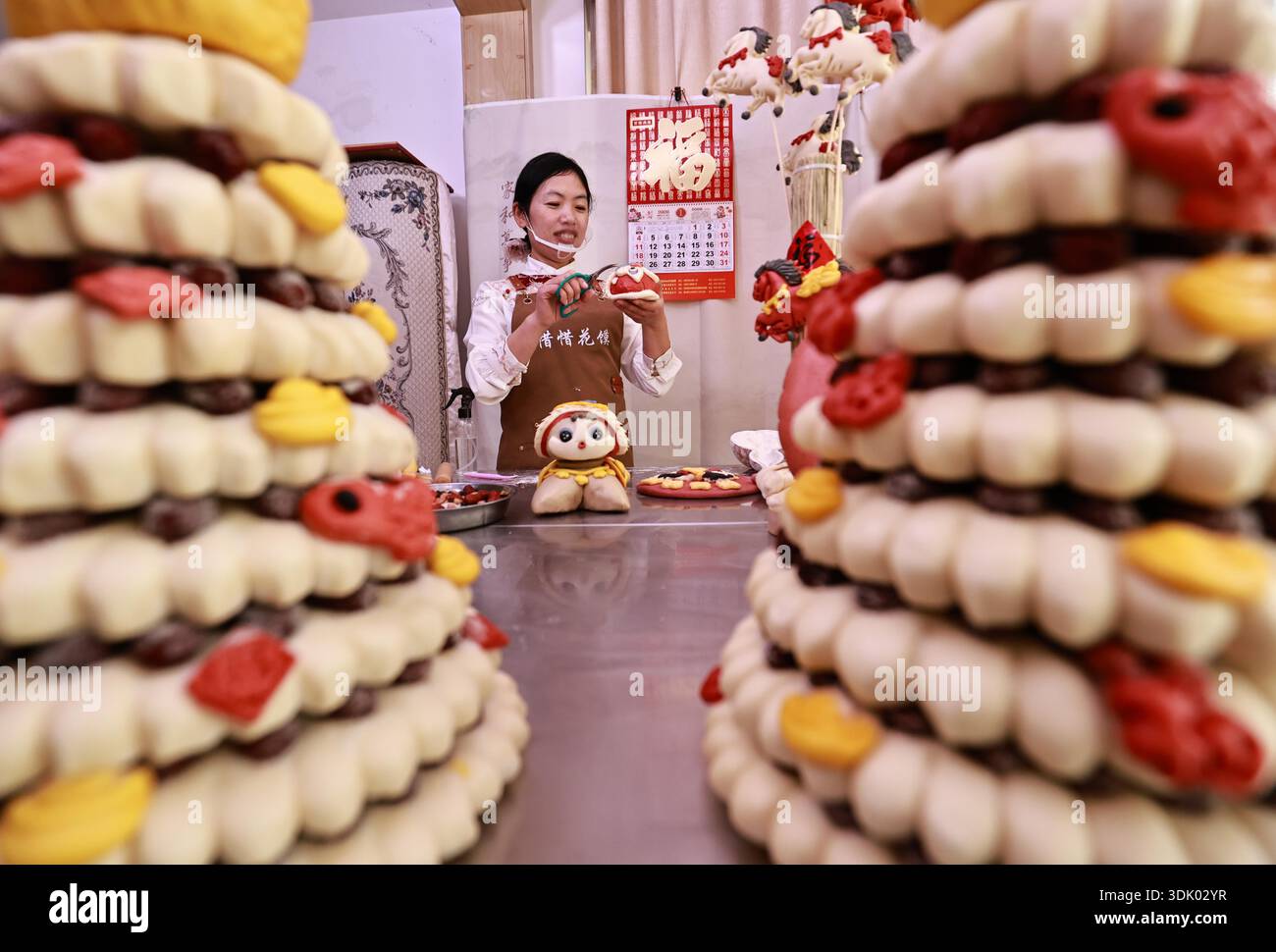 A worker displays freshly steamed traditional flower buns at a heritage ...