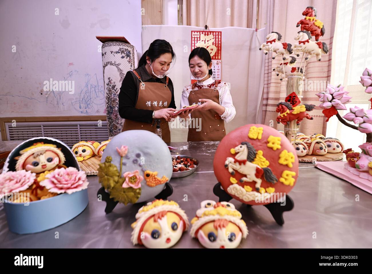 A worker displays freshly steamed traditional flower buns at a heritage ...