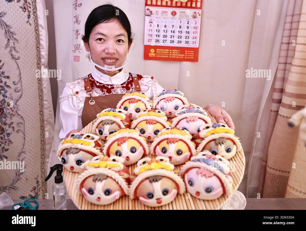 A worker displays freshly steamed traditional flower buns at a heritage ...