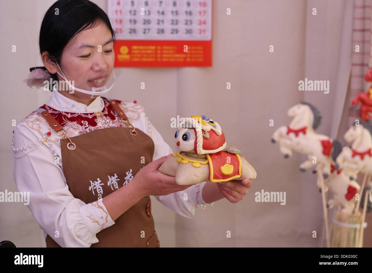 A worker displays freshly steamed traditional flower buns at a heritage ...