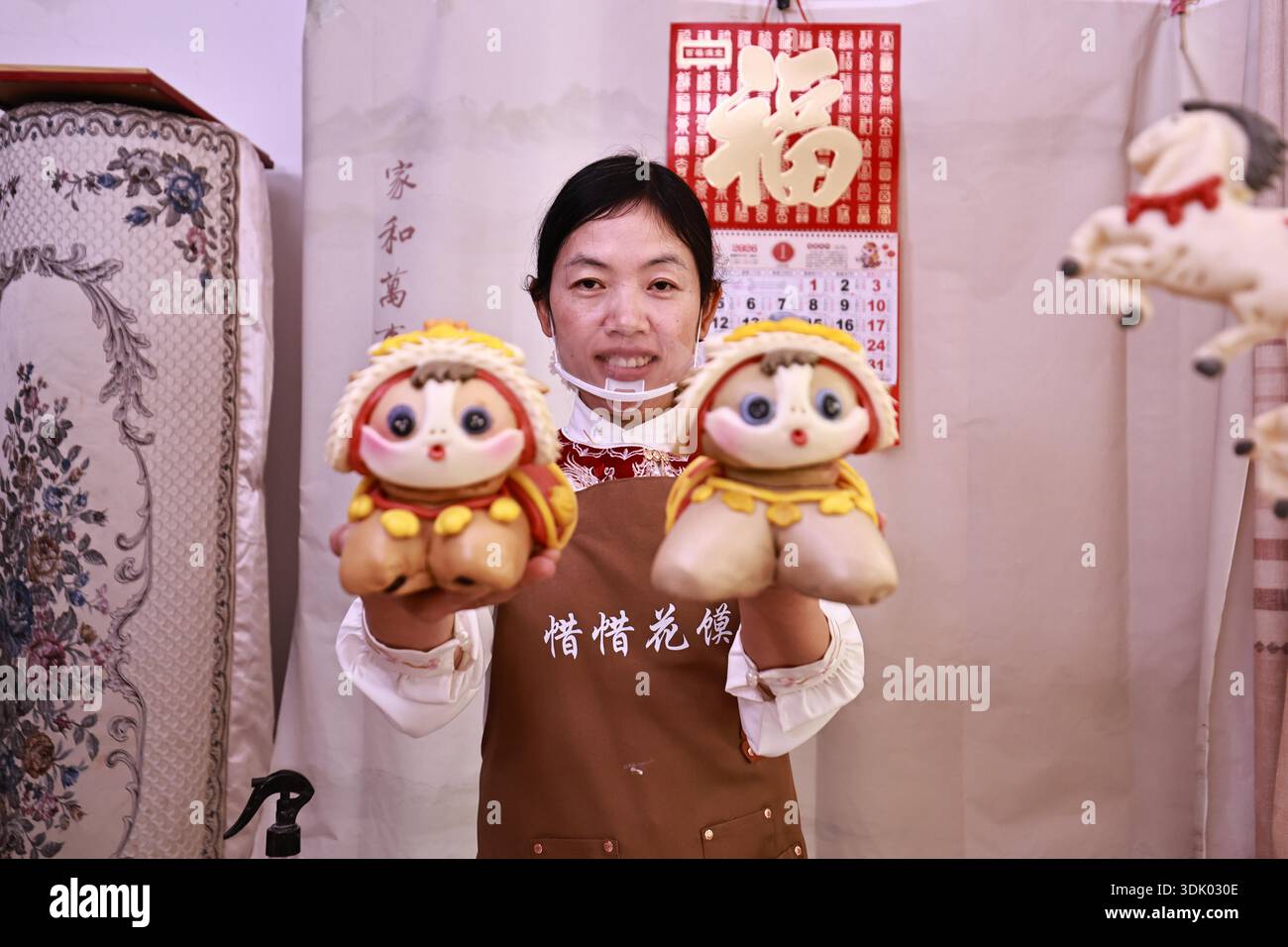 A worker displays freshly steamed traditional flower buns at a heritage ...