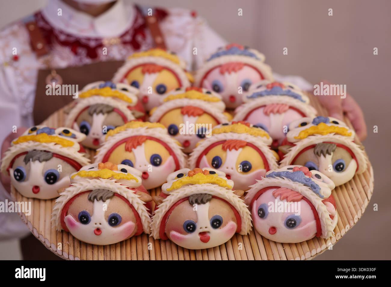 A worker displays freshly steamed traditional flower buns at a heritage ...