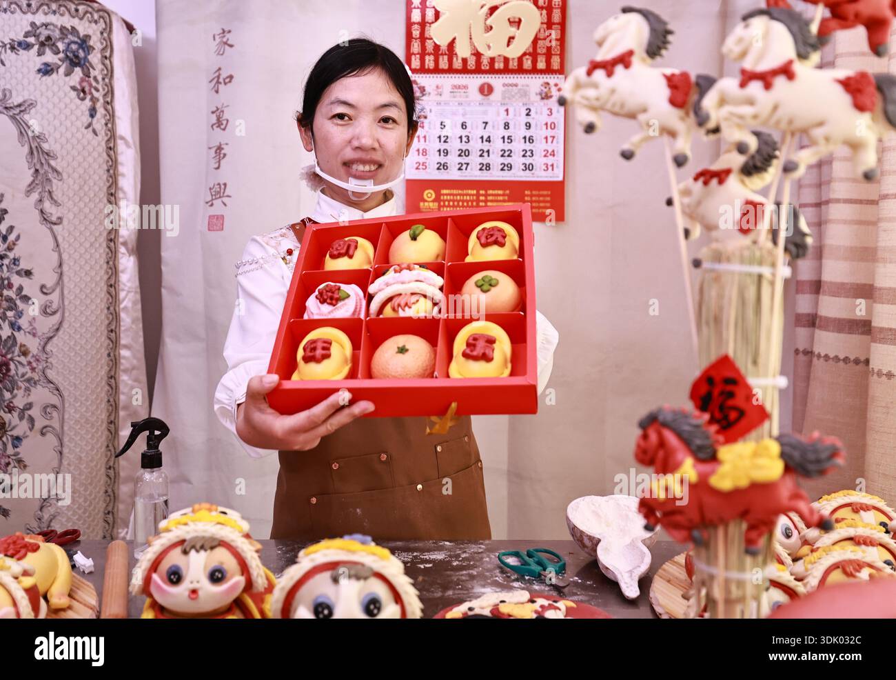 A worker displays freshly steamed traditional flower buns at a heritage ...