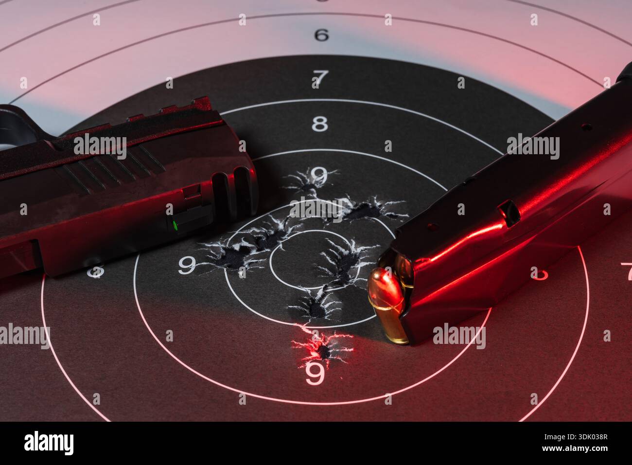 A black handgun and loaded magazine placed on a paper shooting target ...