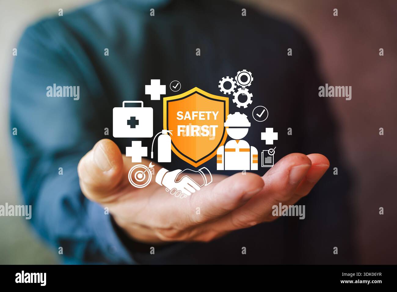 Hand presenting safety first shield with icons for first aid, worker ...