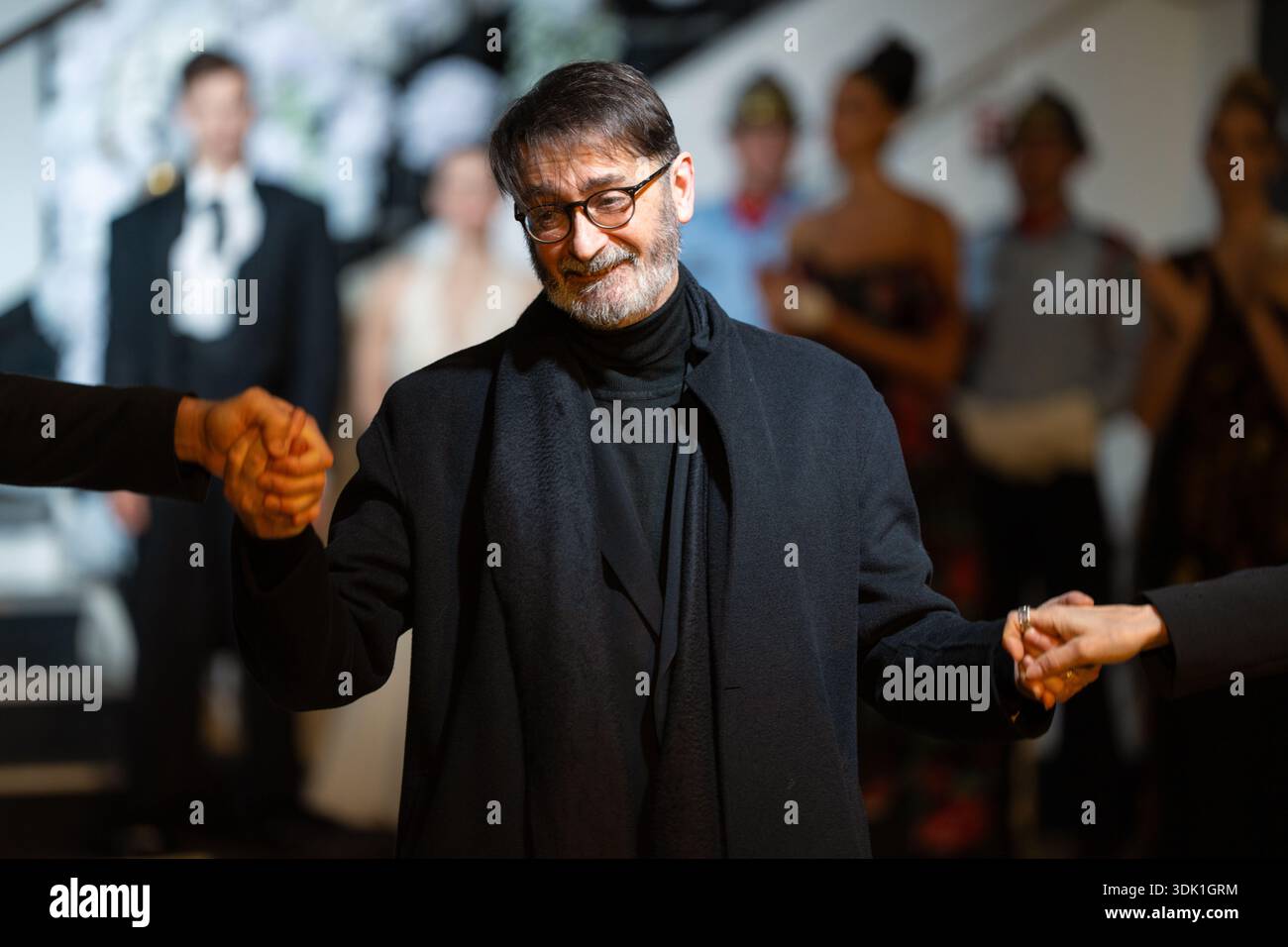 A model walks the runway as Firemen pose during the Franck Sorbier ...