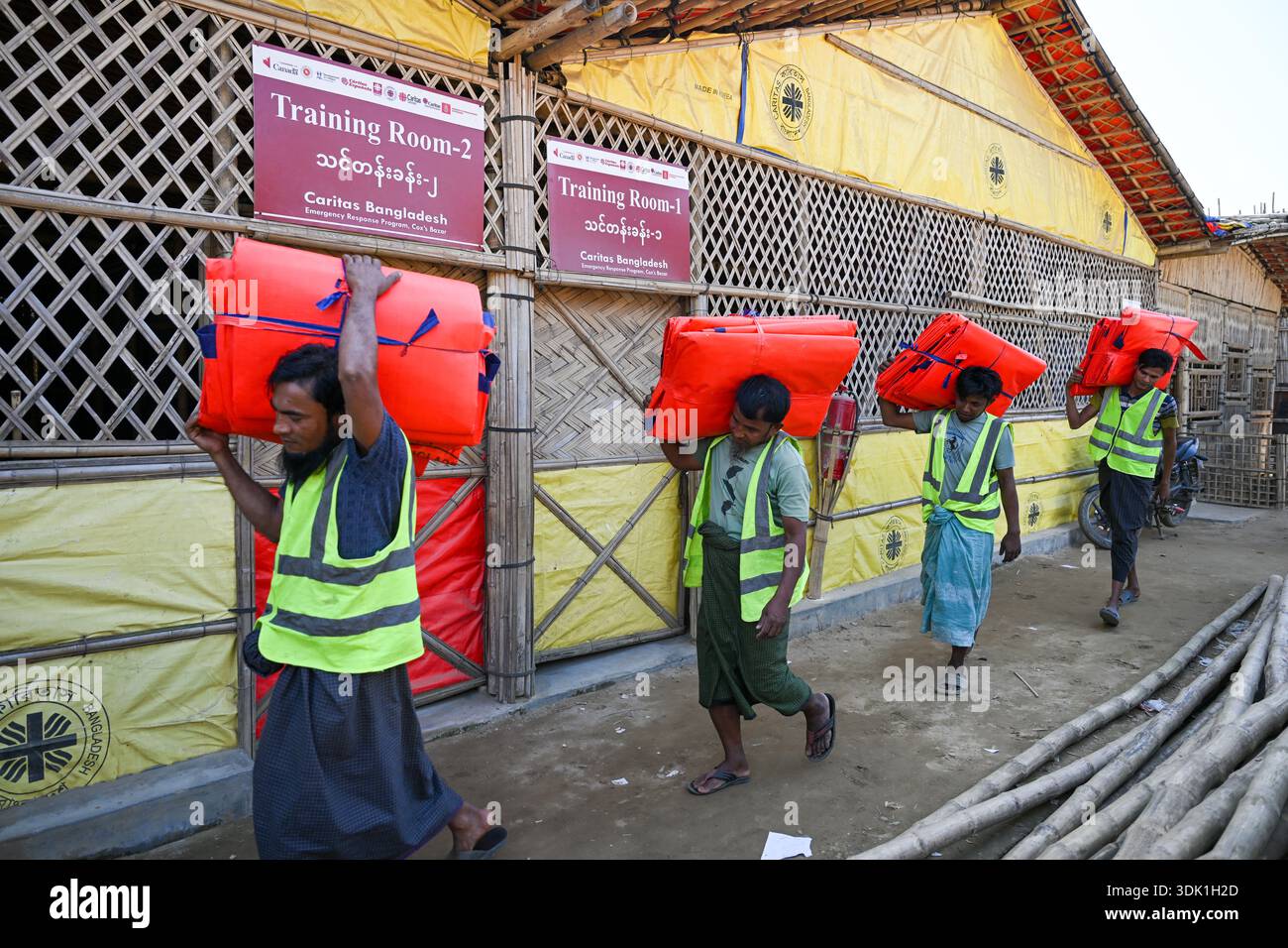 Rohingya volunteers work together to repair their shelter inside a ...
