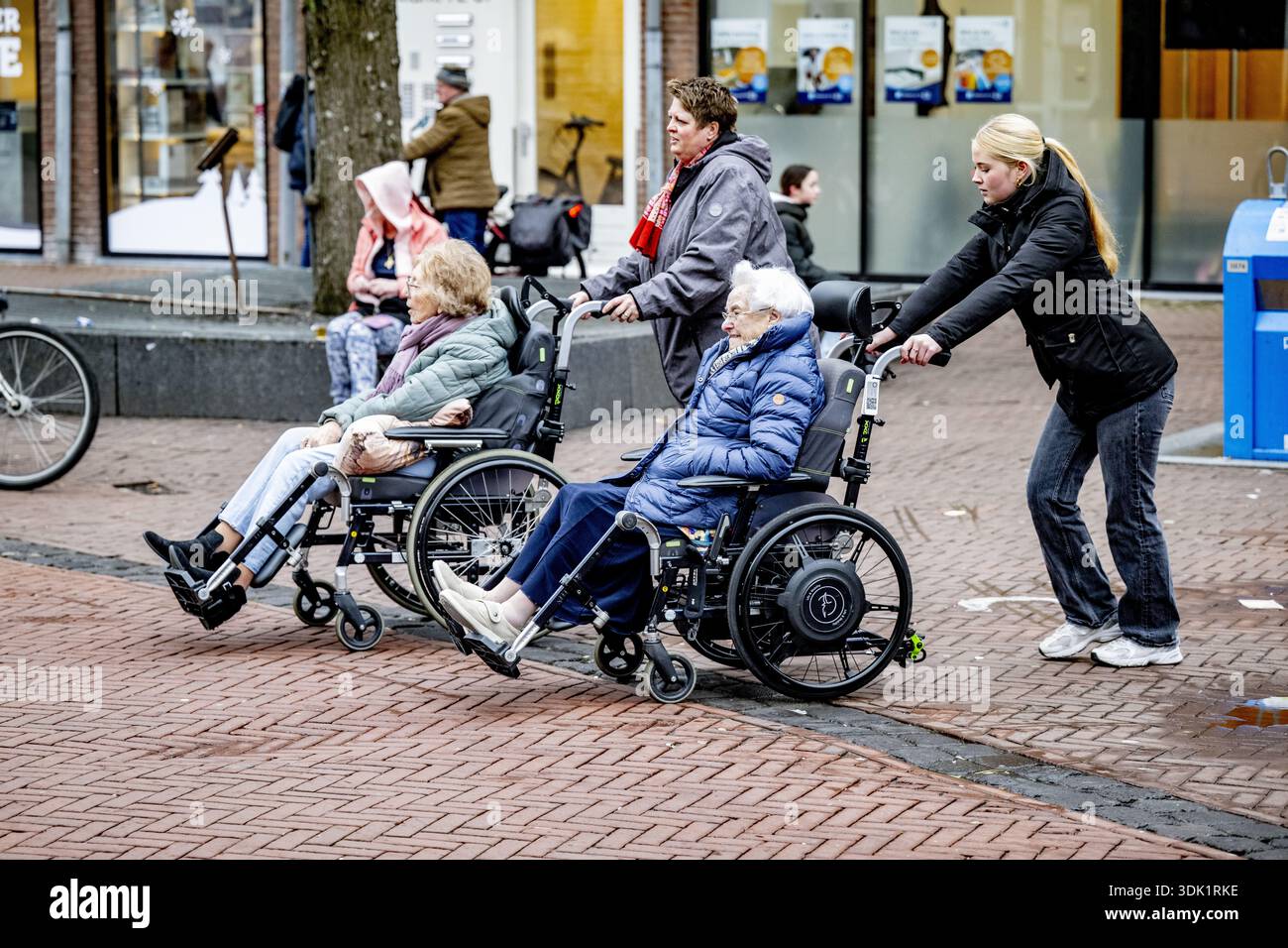 GOUDA - Walking on the street with a person in a wheelchair ROBIN ...