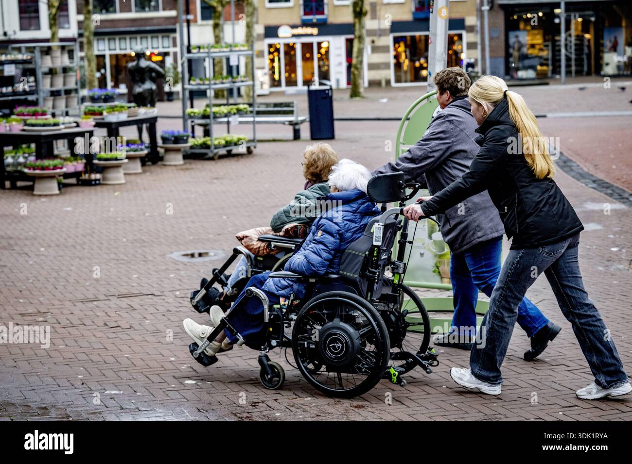 GOUDA - Walking on the street with a person in a wheelchair ROBIN ...