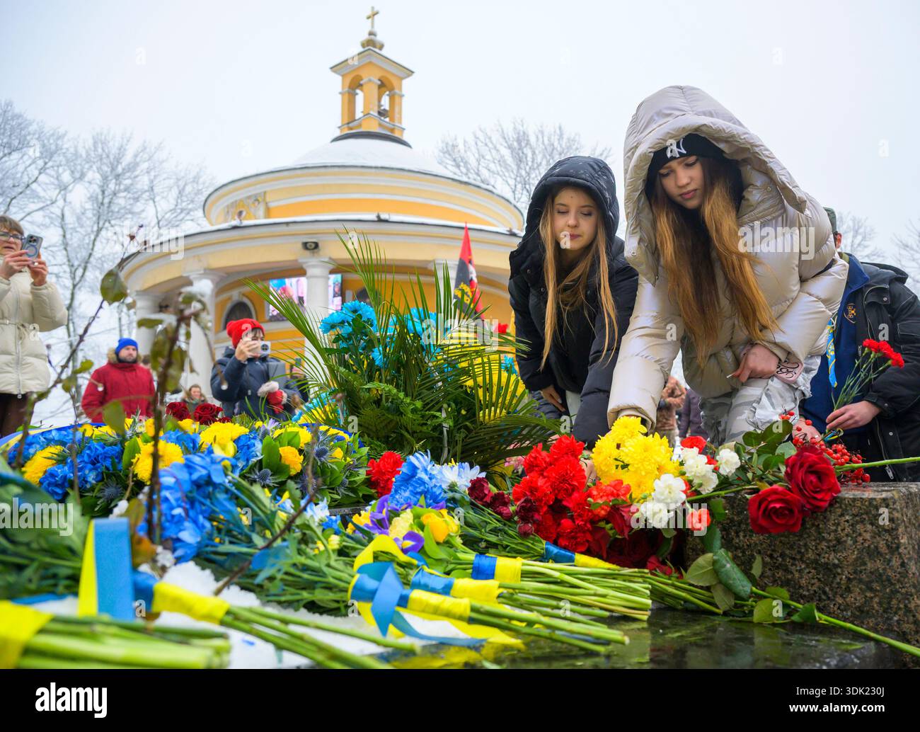 Kyiv, Ukraine - 29th January,2026: Young people placing flowers at a ...