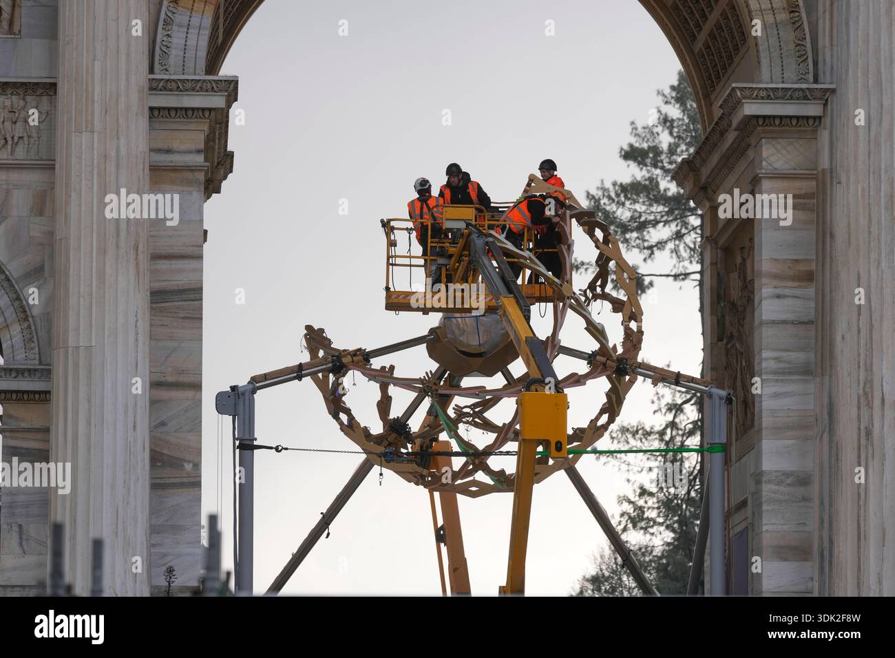 Workers set the Olympics cauldron at the Peace arch in Milan, Italy ...