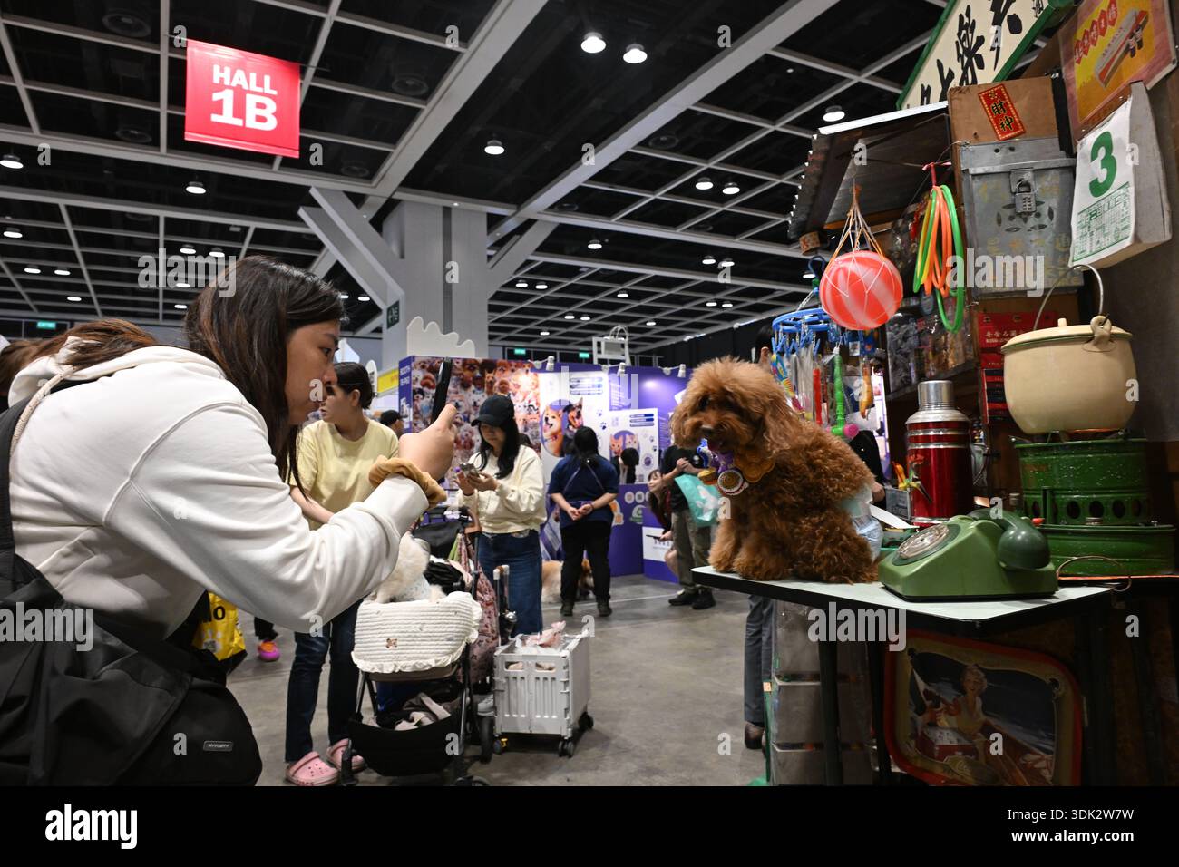 A lady taking photo with her dog on store exhibit of Hong Kong Pet Show ...
